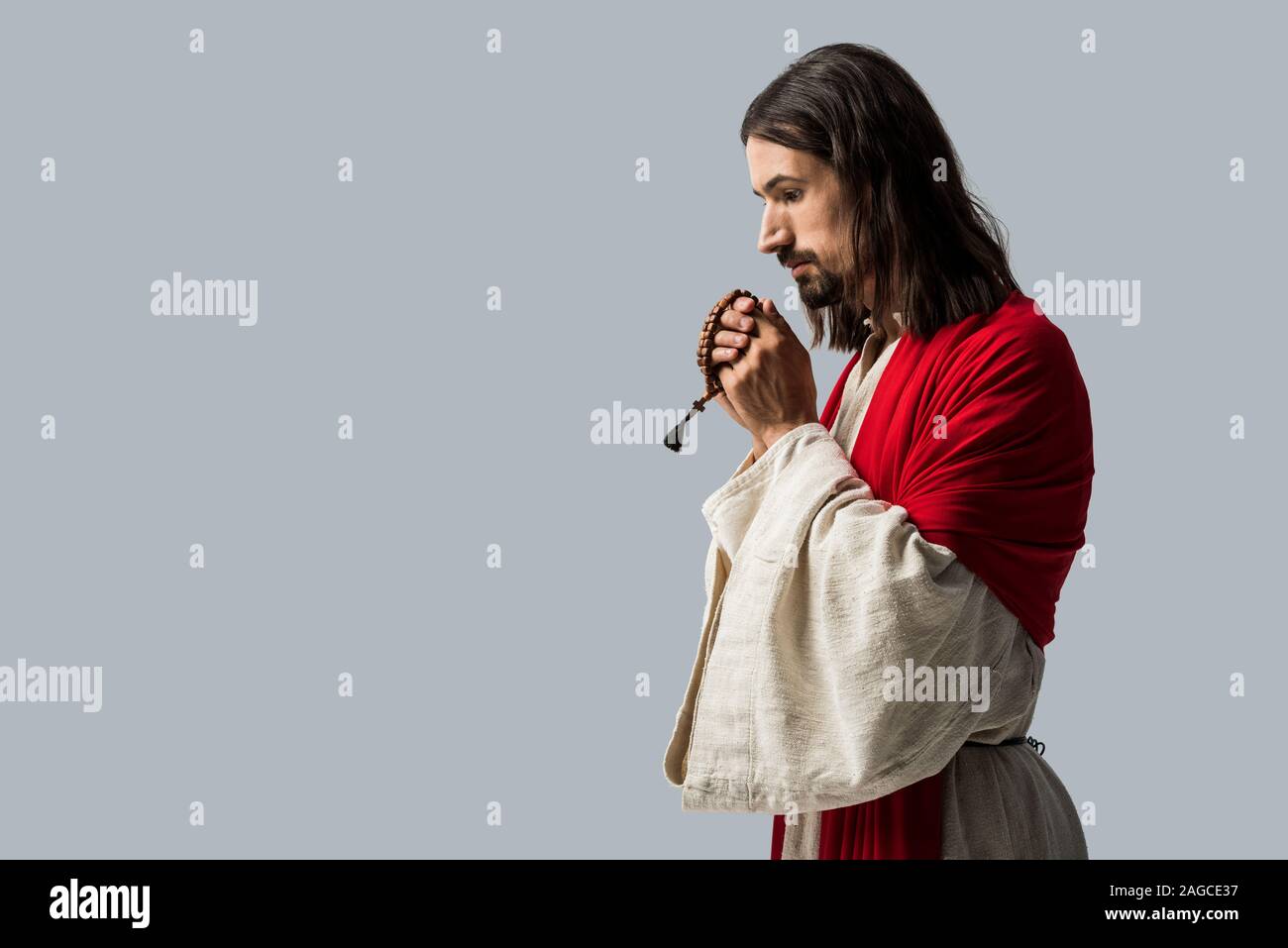 religious man holding rosary beads while praying isolated on grey Stock ...