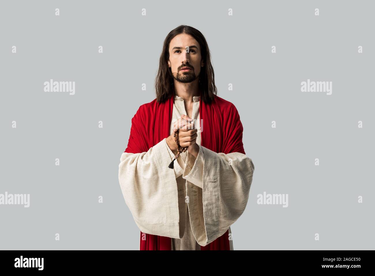 handsome man praying with clenched hands isolated on grey Stock Photo ...