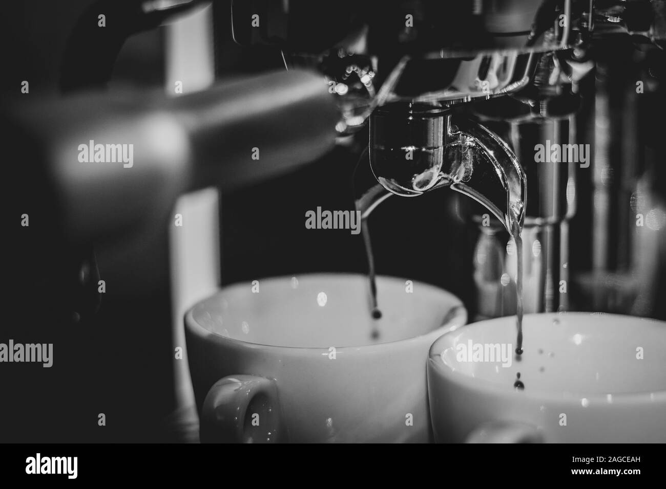 A black and white portrait of the nozzle of a coffee machine. Freshly ...