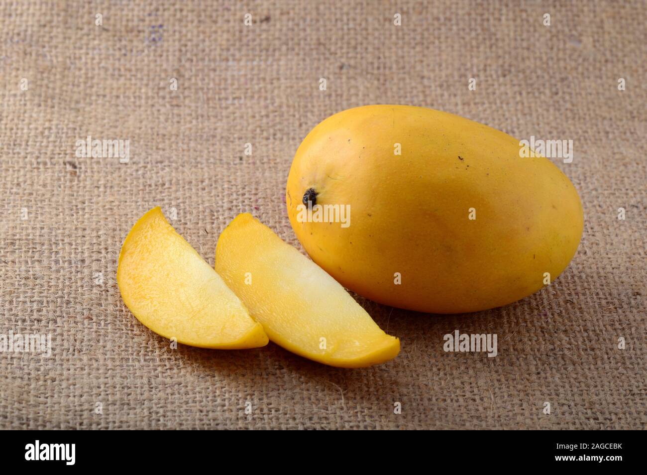 Mango fruit with slice on sack cloth background Stock Photo - Alamy