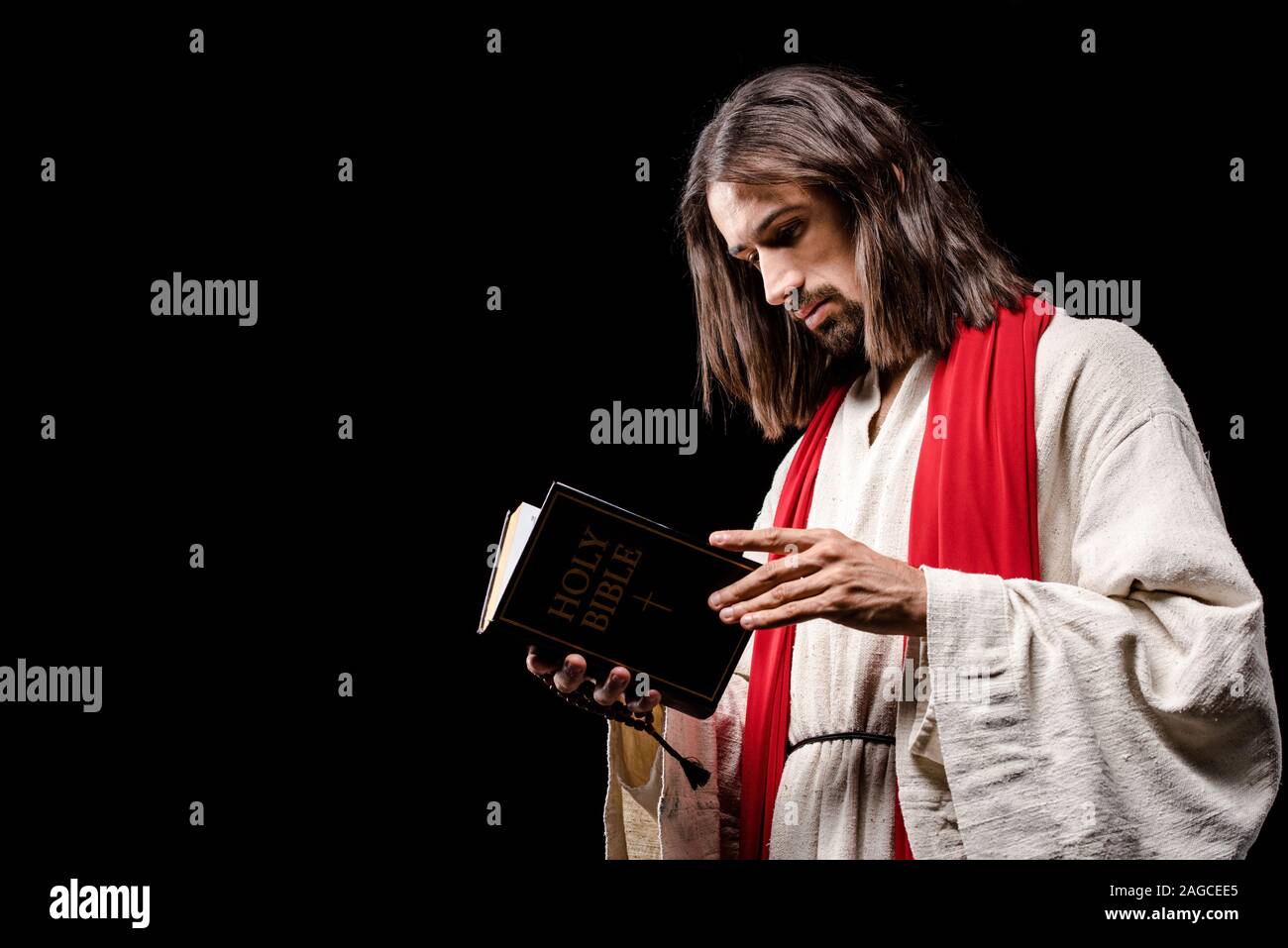 religious man holding book with holy bible lettering isolated on black ...
