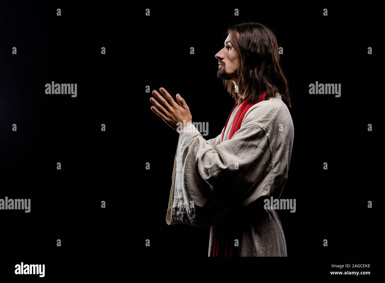 side view of man with praying hands isolated on black Stock Photo - Alamy