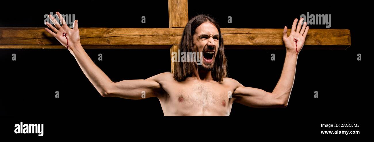 panoramic shot of shirtless man crucified on wooden cross screaming ...