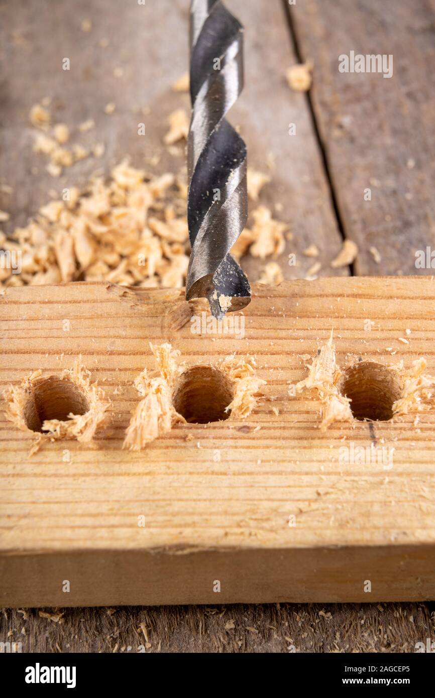 Drilling with a drill bit into wood. Small carpentry work in a ...