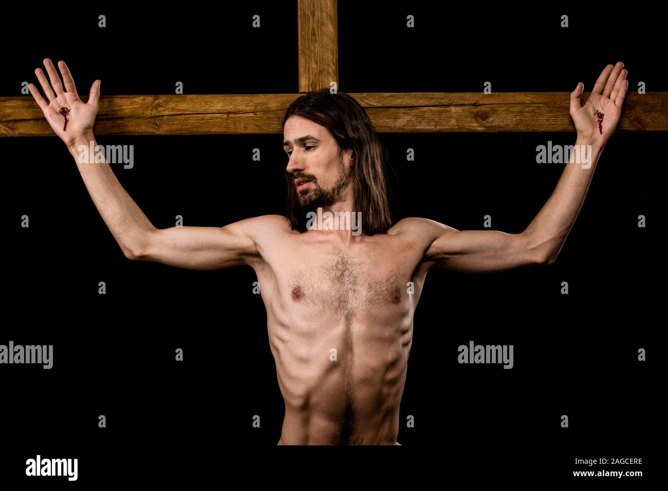 shirtless man crucified on wooden cross isolated on black Stock Photo ...