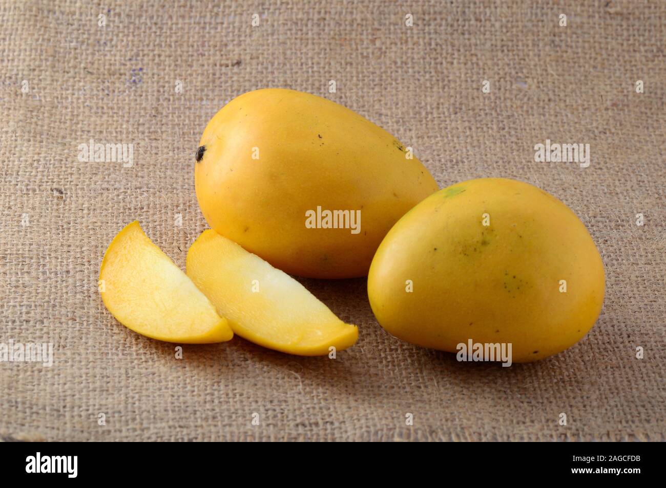 Mango fruit with slice on sack cloth background Stock Photo - Alamy