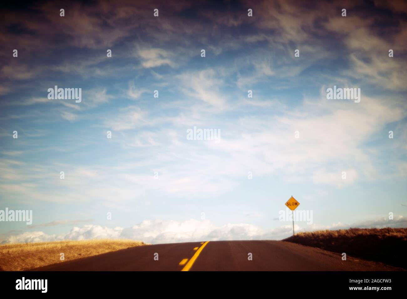 Rural Highway with "Slow" Road sign Stock Photo - Alamy