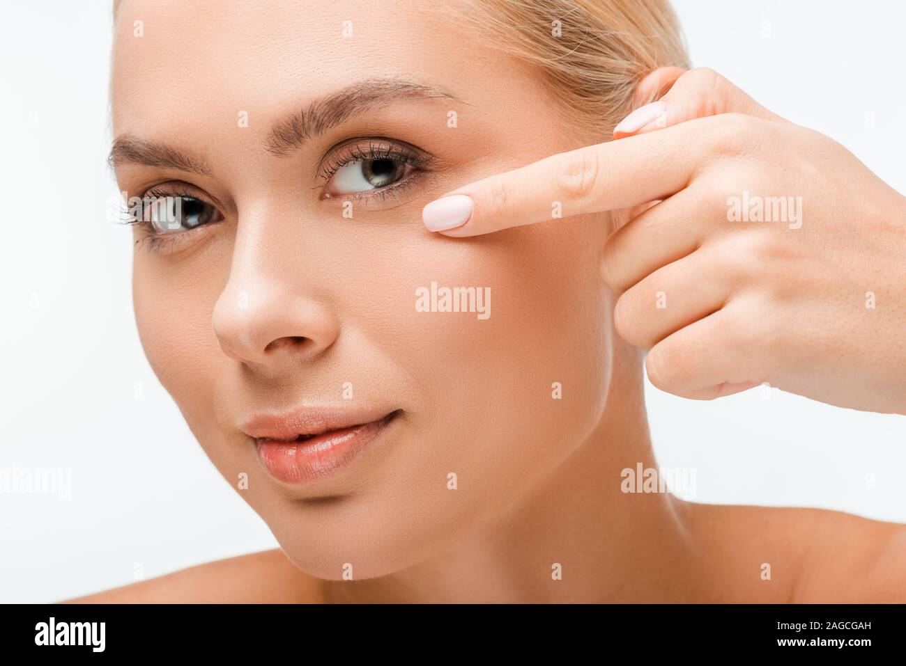 beautiful woman pointing with finger at clean face isolated on white ...