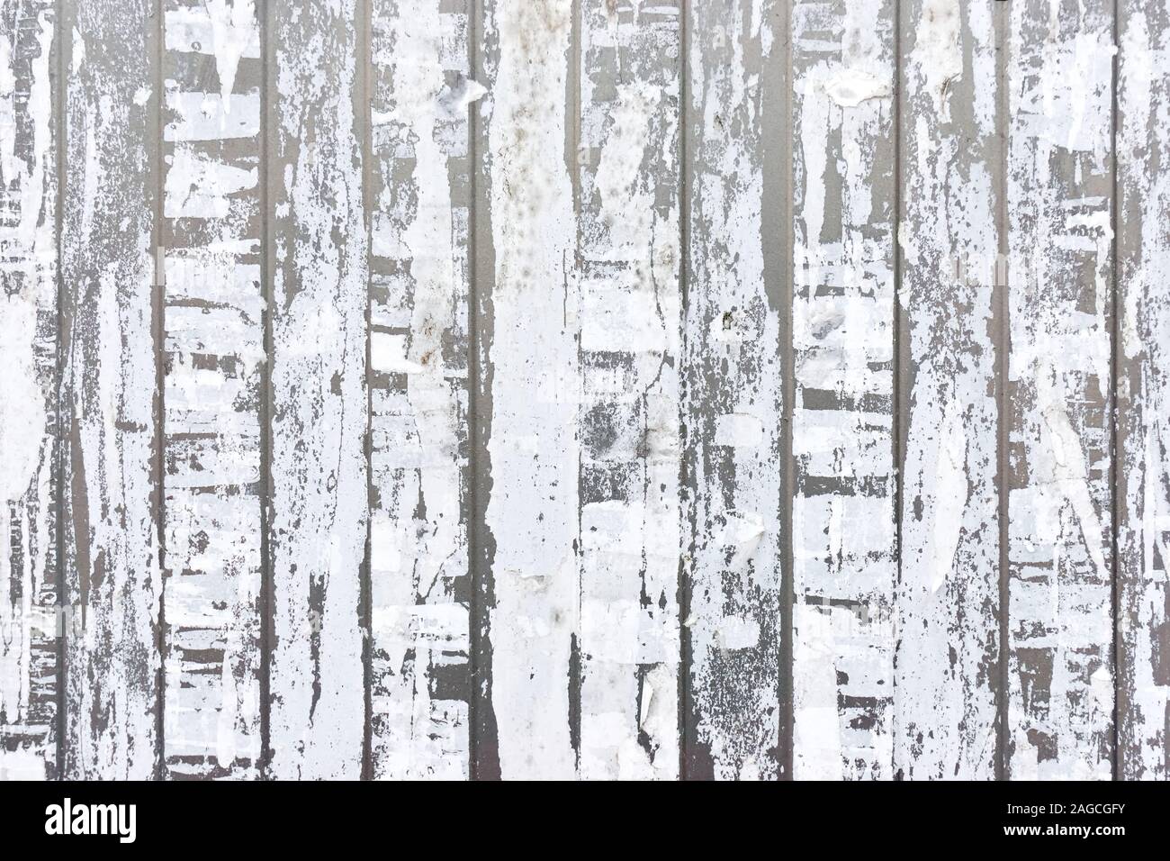 Close-up of vertical strips of white torn paper on a light gray metal ...