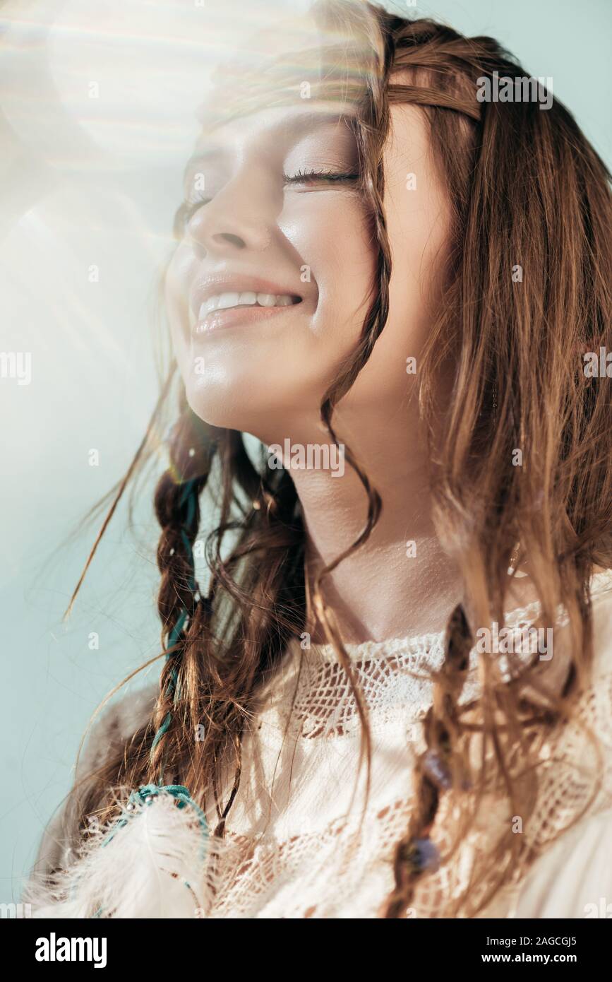 happy bohemian girl with braids in hairstyle posing in white boho dress ...