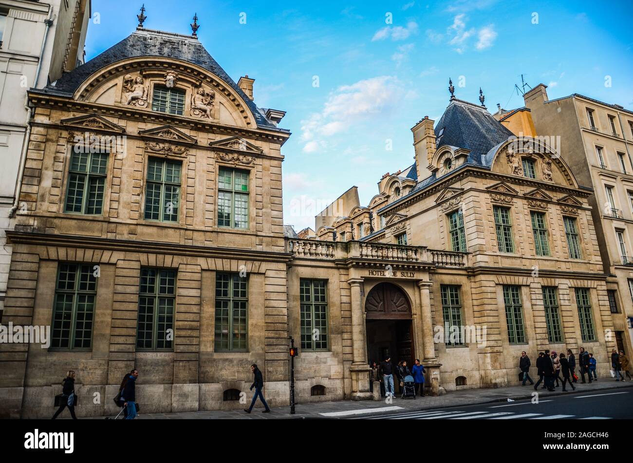PARIS, FRANCE - Feb 22, 2019: People walking by an ancient architecture ...