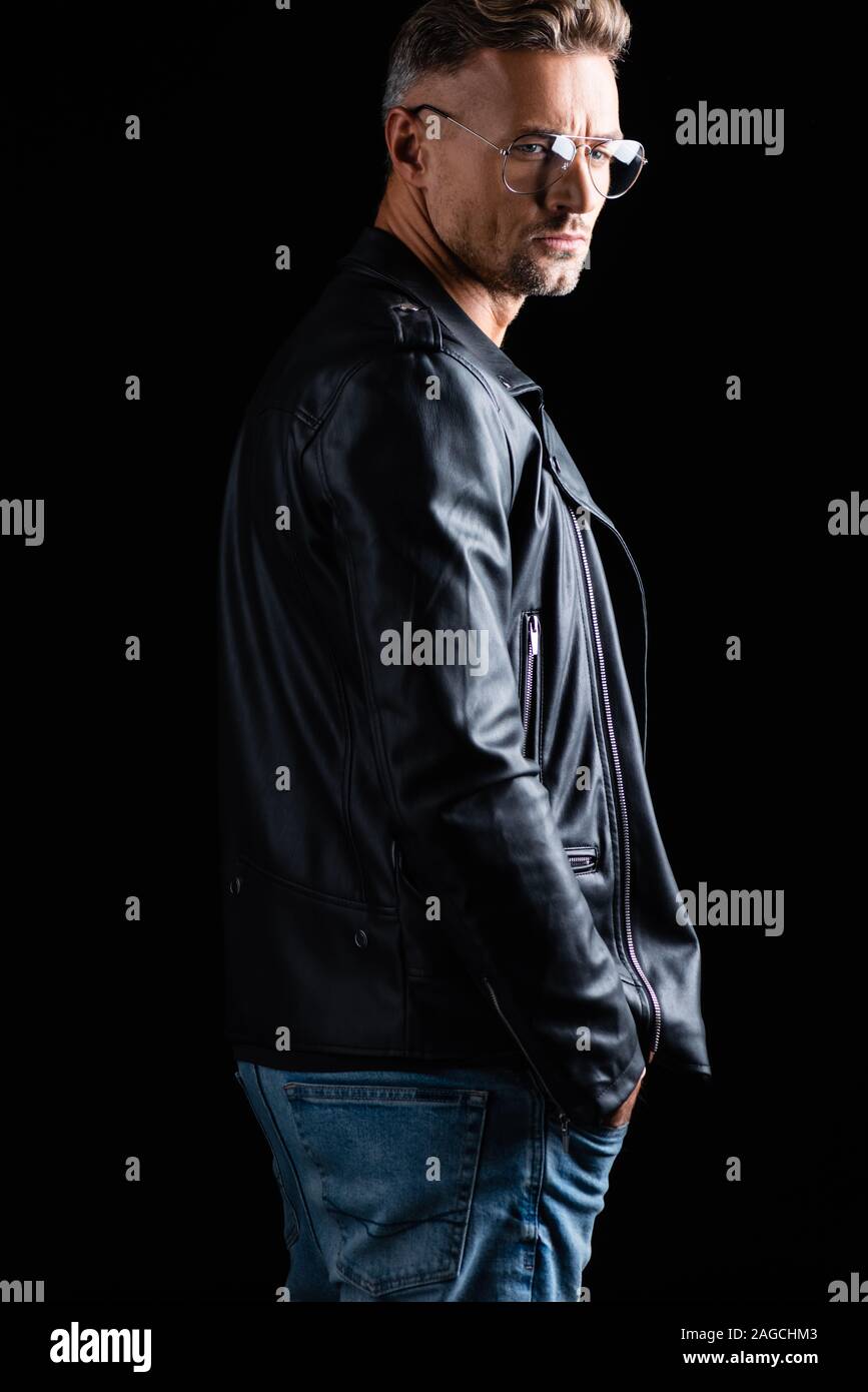 Side view of handsome man in leather jacket and sunglasses looking away ...