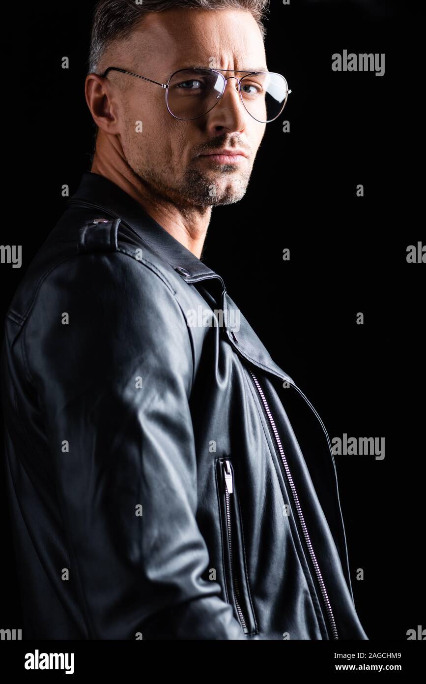 Side view of handsome man in leather jacket looking at camera isolated ...