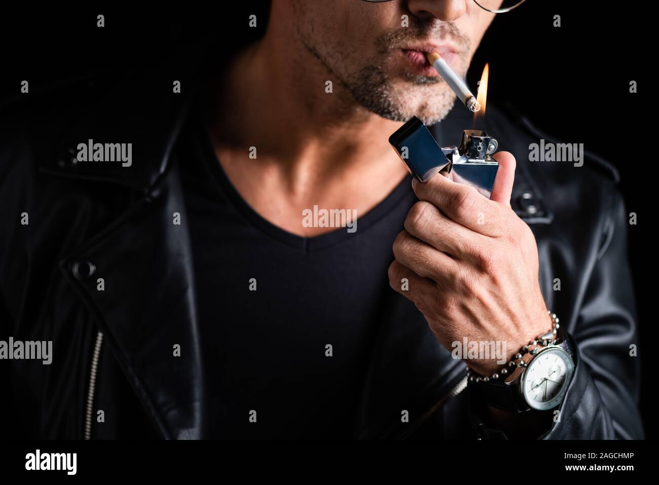 Cropped view of man lighting cigarette with lighter isolated on black Stock Photo - Alamy