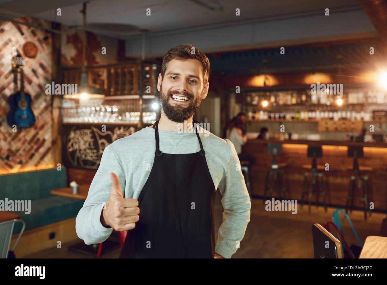 Bearded barman waiter raised his thumb up a restaurant pub bar Stock ...