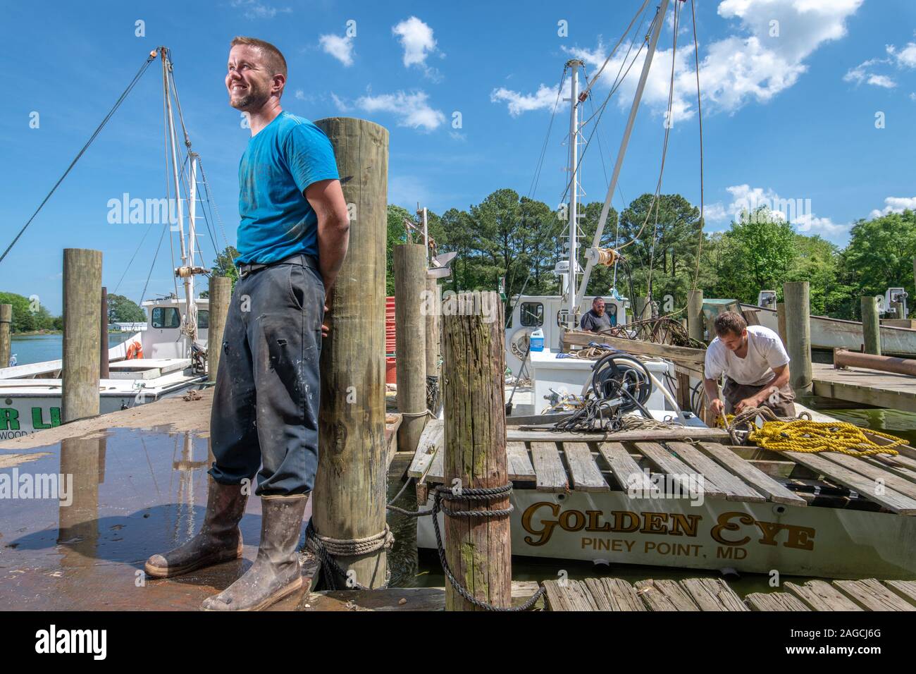A waterman smiling after a hard days work in front of the boat , Tall ...