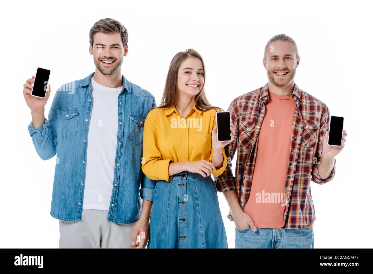 smiling three young friends holding smartphones with blank screens ...