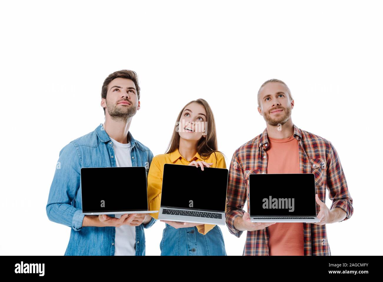 three young dreamy friends holding laptops with blank screens isolated ...