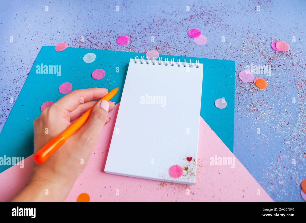 Colorful confetti, sparkles and notebook with wish list on bright ...