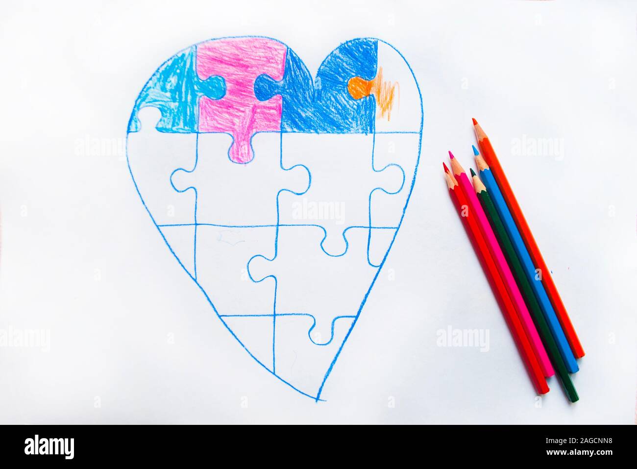 Colorful child drawn heart with jigsaw puzzle on white background as a ...