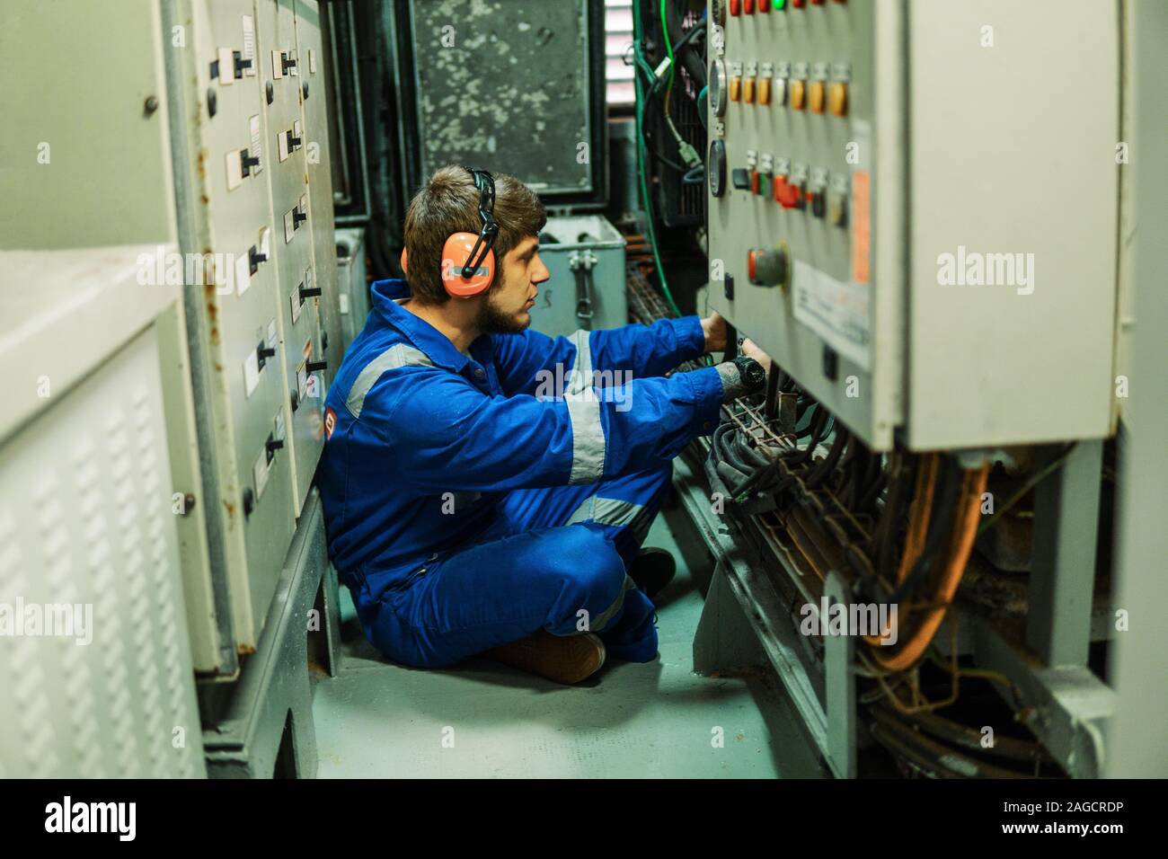 Marine engineer inspecting ship's engine or generators Stock Photo - Alamy
