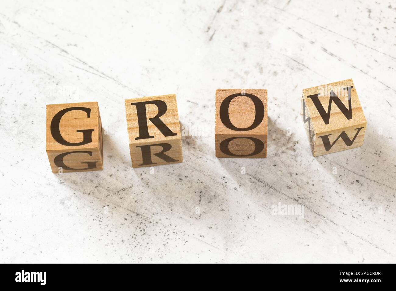 Four wooden cubes with word GROW on white working board Stock Photo - Alamy