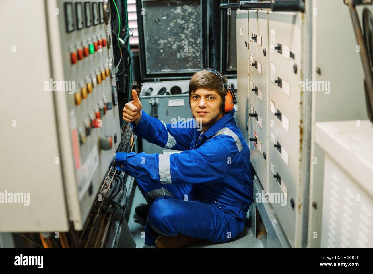 Marine engineer inspecting ship's engine or generators Stock Photo - Alamy