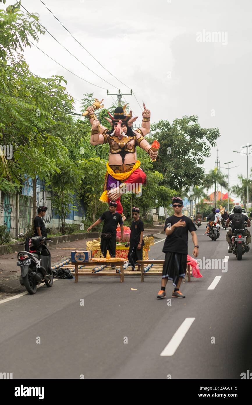 Parade on the street of the island of Bali. Teenagers carry a huge ...