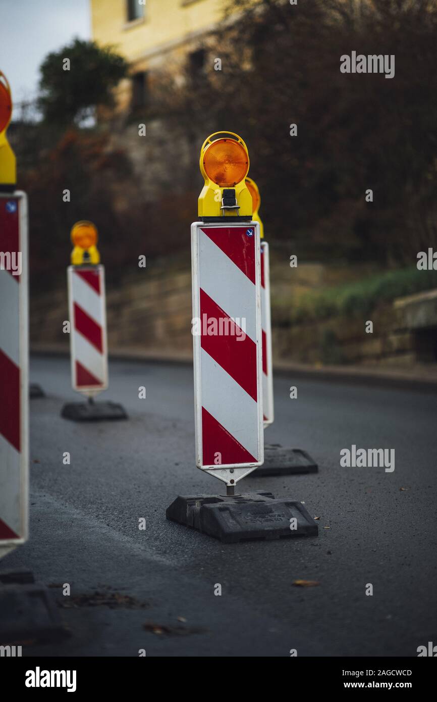 Vertical shot of street signs on the road with a blurred background ...