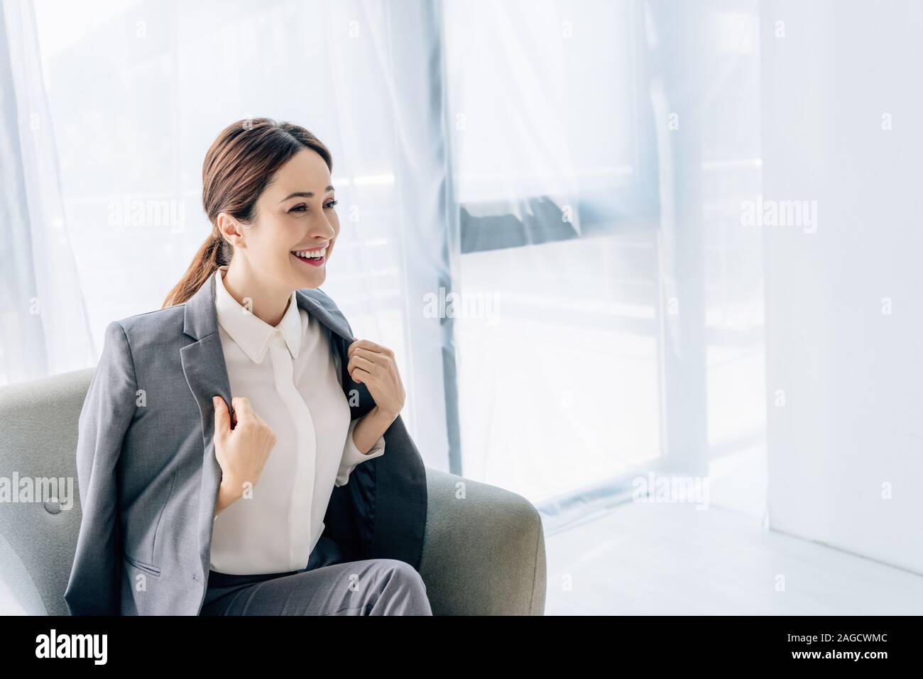 attractive journalist in formal wear smiling in sunny office Stock ...