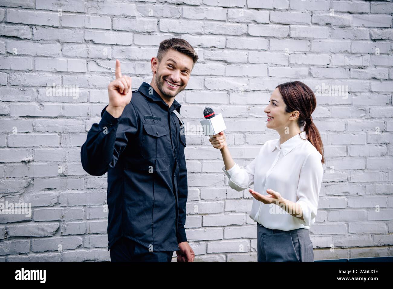 journalist holding microphone and talking with handsome policeman in ...