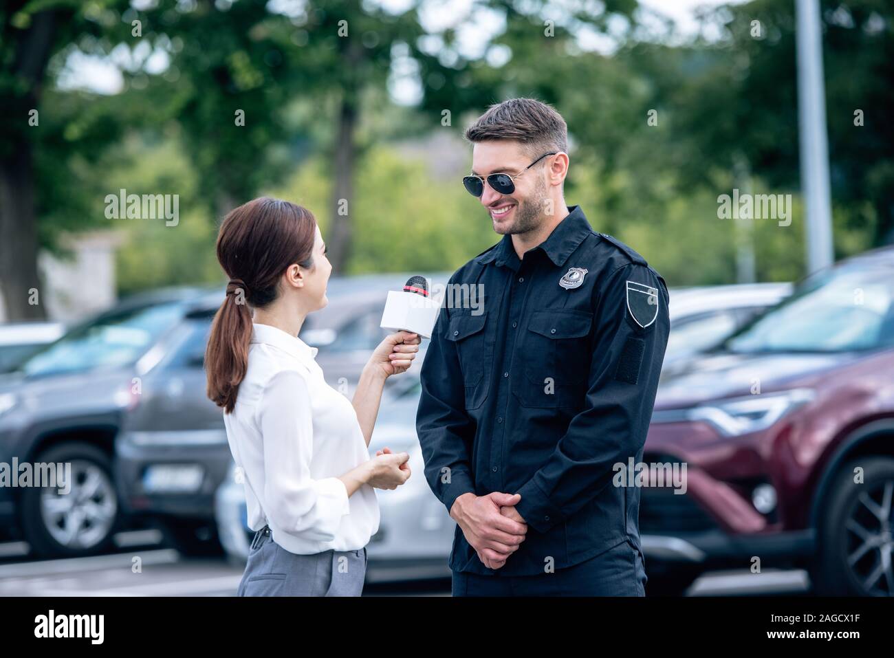 journalist holding microphone and talking with handsome policeman in ...