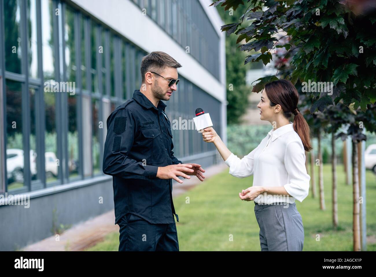 journalist holding microphone and talking with handsome policeman in ...