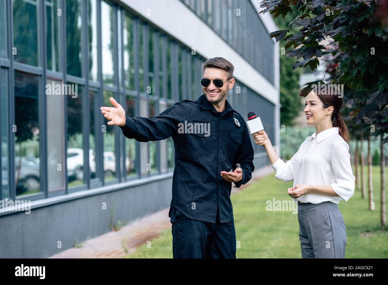 journalist holding microphone and talking with handsome policeman in ...