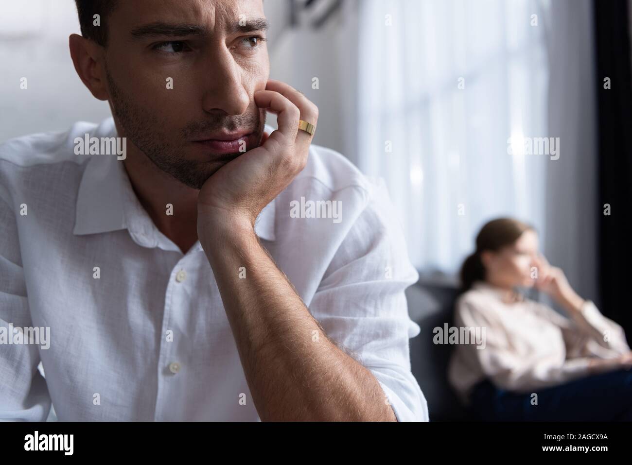 pensive sad man with ring and wife on sofa Stock Photo - Alamy