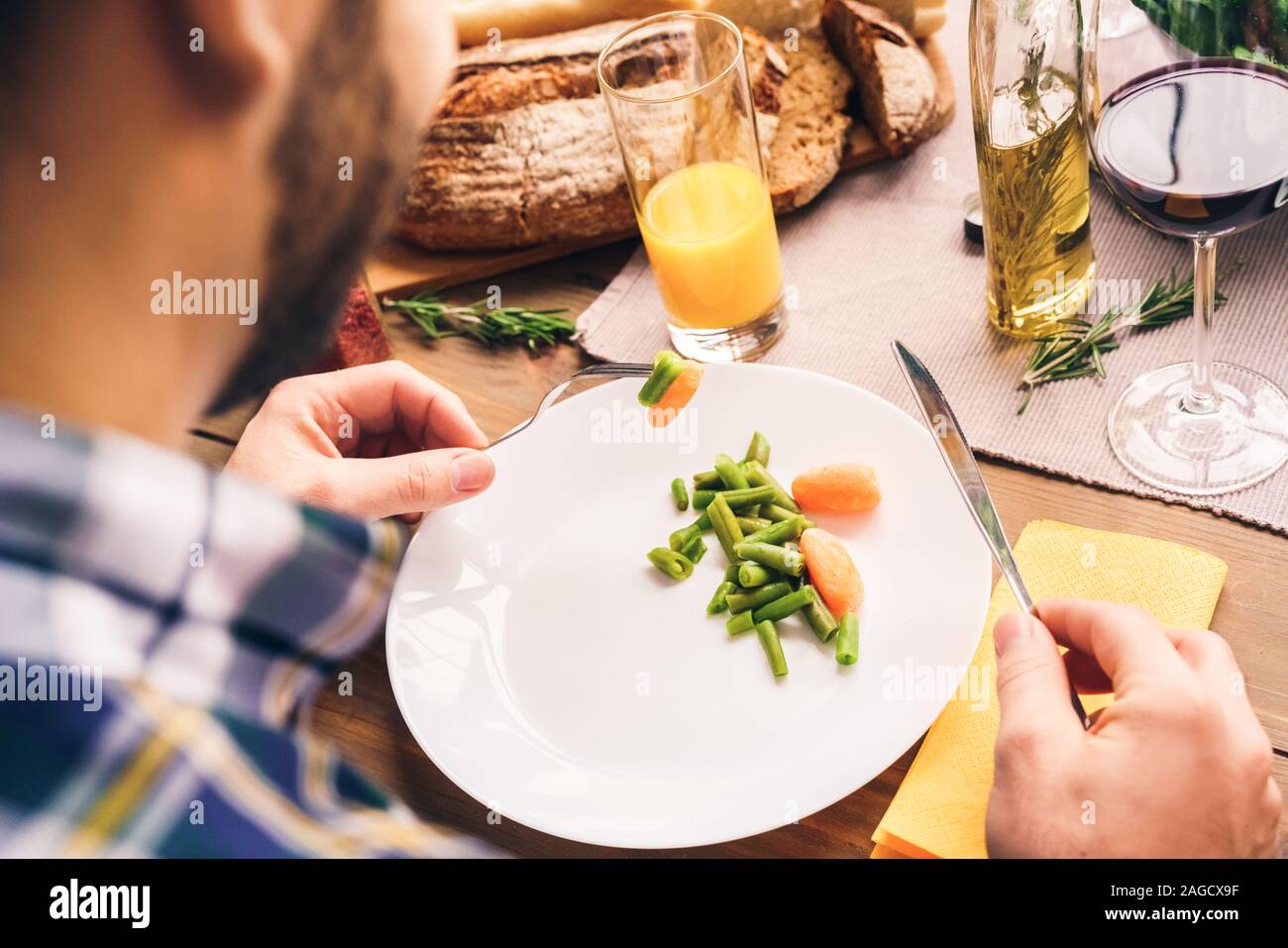 Man sitting at home behind table, eating healthy food Stock Photo - Alamy