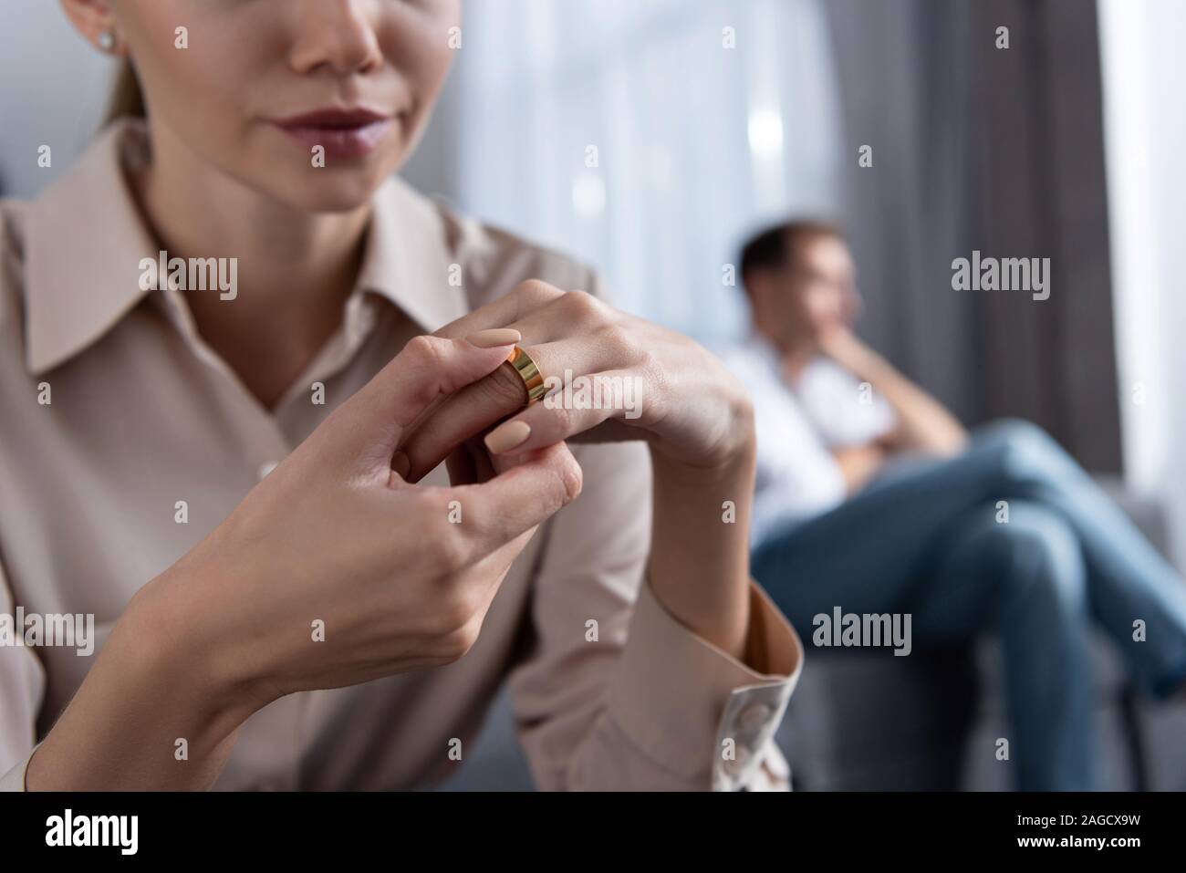 partial view of upset woman taking off ring and man on sofa Stock Photo ...