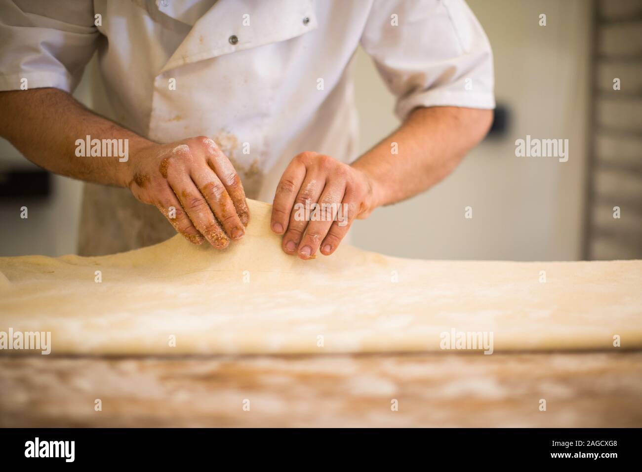 Professional chief making a pastry with dough in a kitchen Stock Photo ...