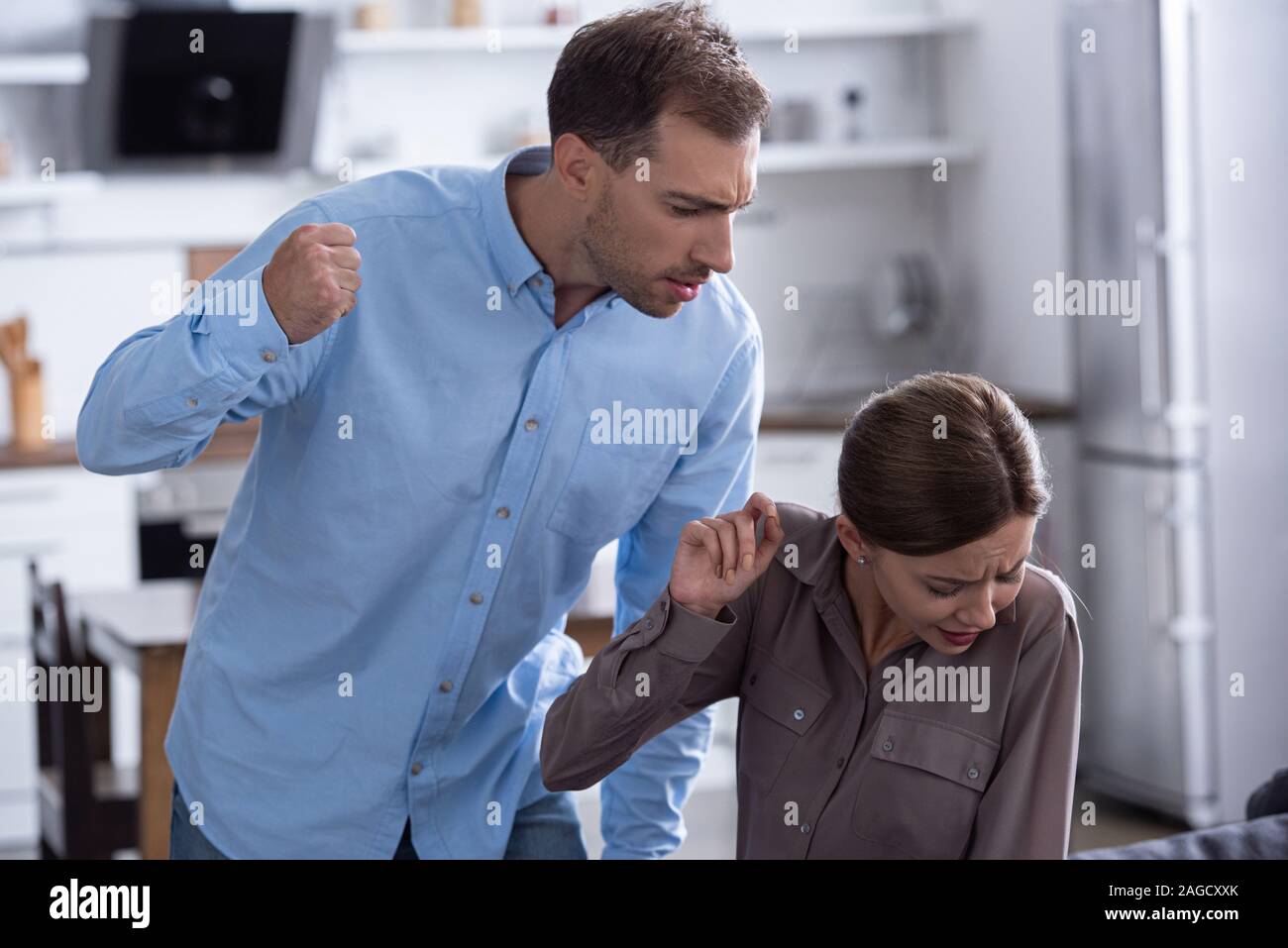 aggressive man in shirt beating scared wife during quarrel Stock Photo ...