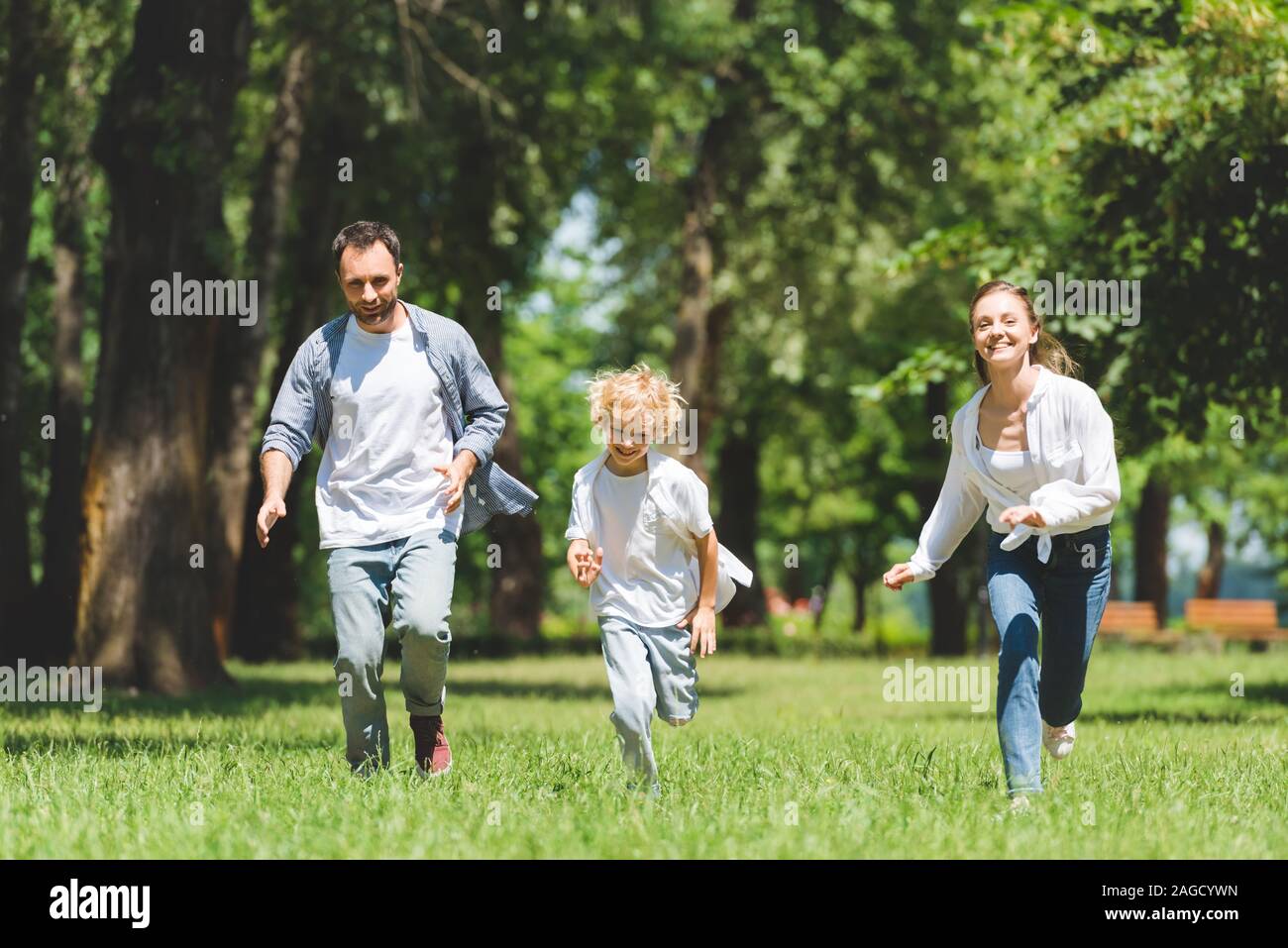 Happy family running in park hi-res stock photography and images - Alamy
