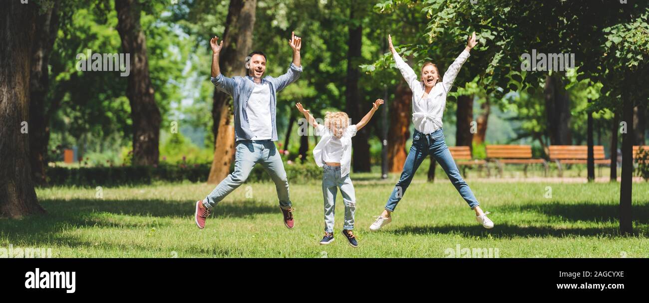 Happy family jumping in park hi-res stock photography and images - Alamy