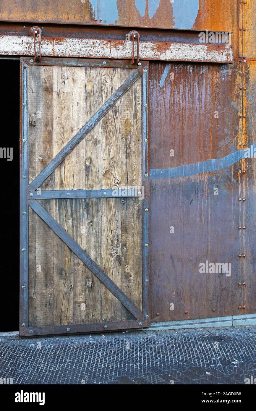 Heavy old wooden sliding door on warehouse entry Stock Photo - Alamy