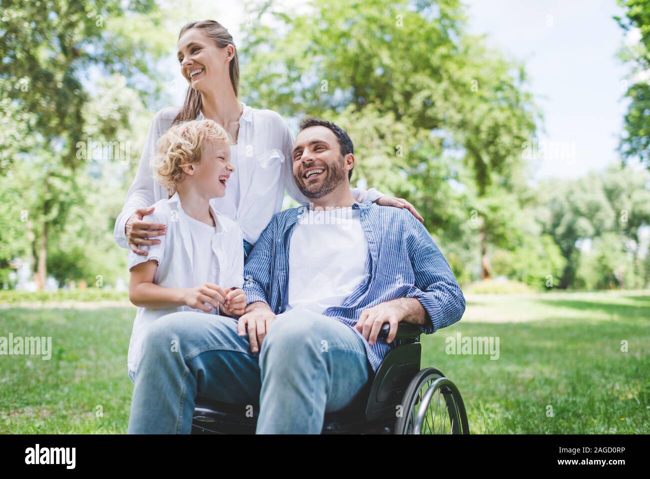 happy family with disabled father on wheelchair in park Stock Photo - Alamy