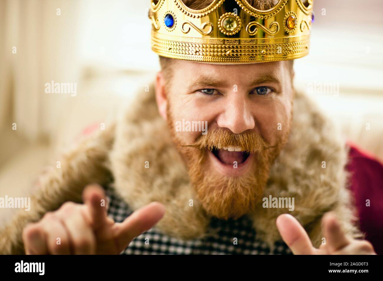 Portrait of excited mid-adult man wearing crown Stock Photo - Alamy