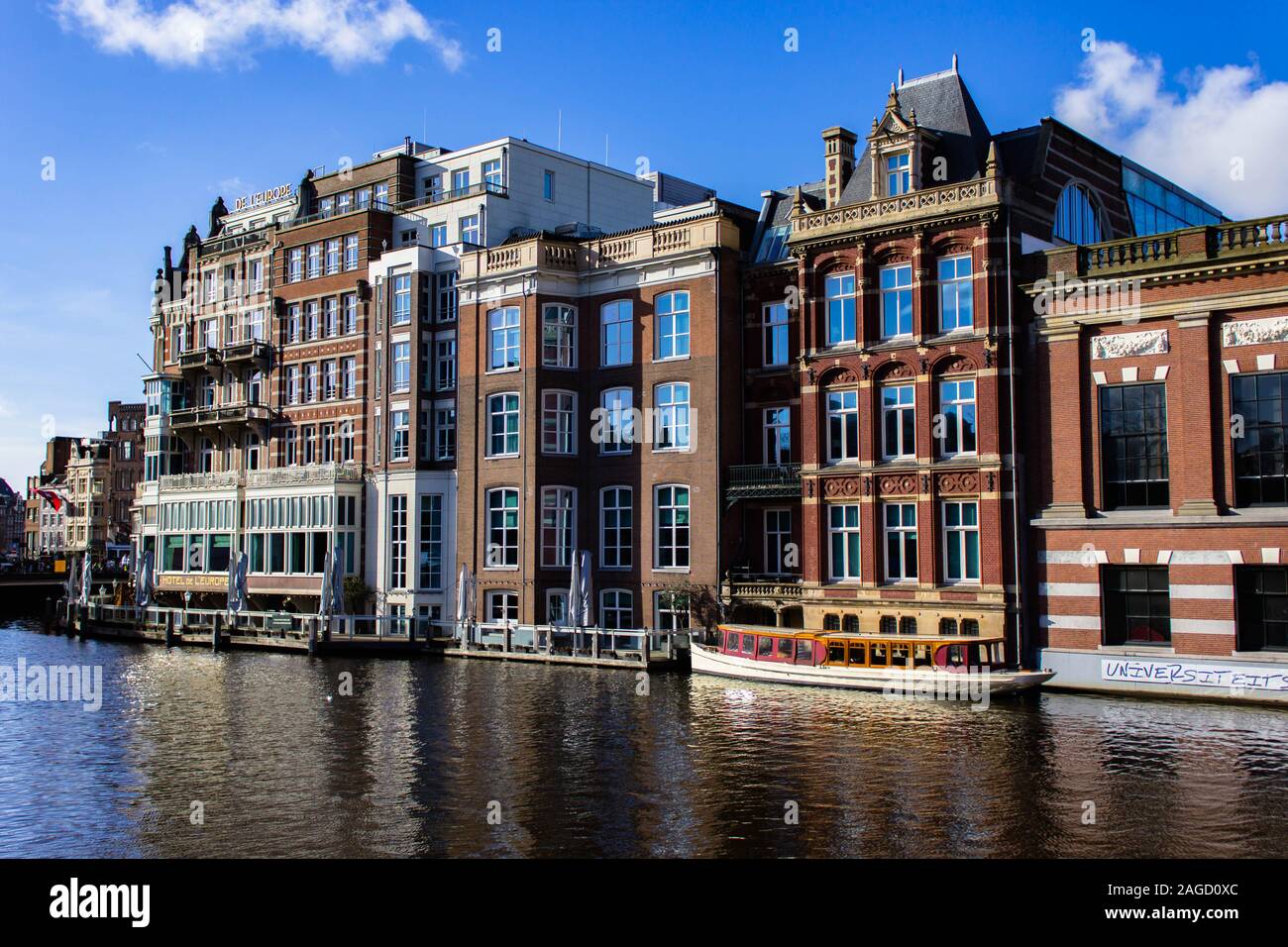 Amsterdam buildings next to river with parked boats Stock Photo - Alamy