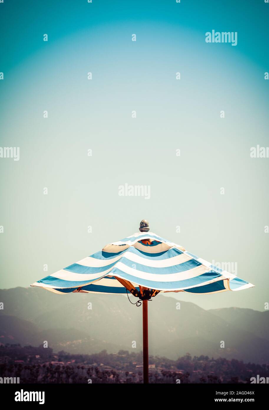 Vertical format of an isolated striped patio umbrella with distant ...