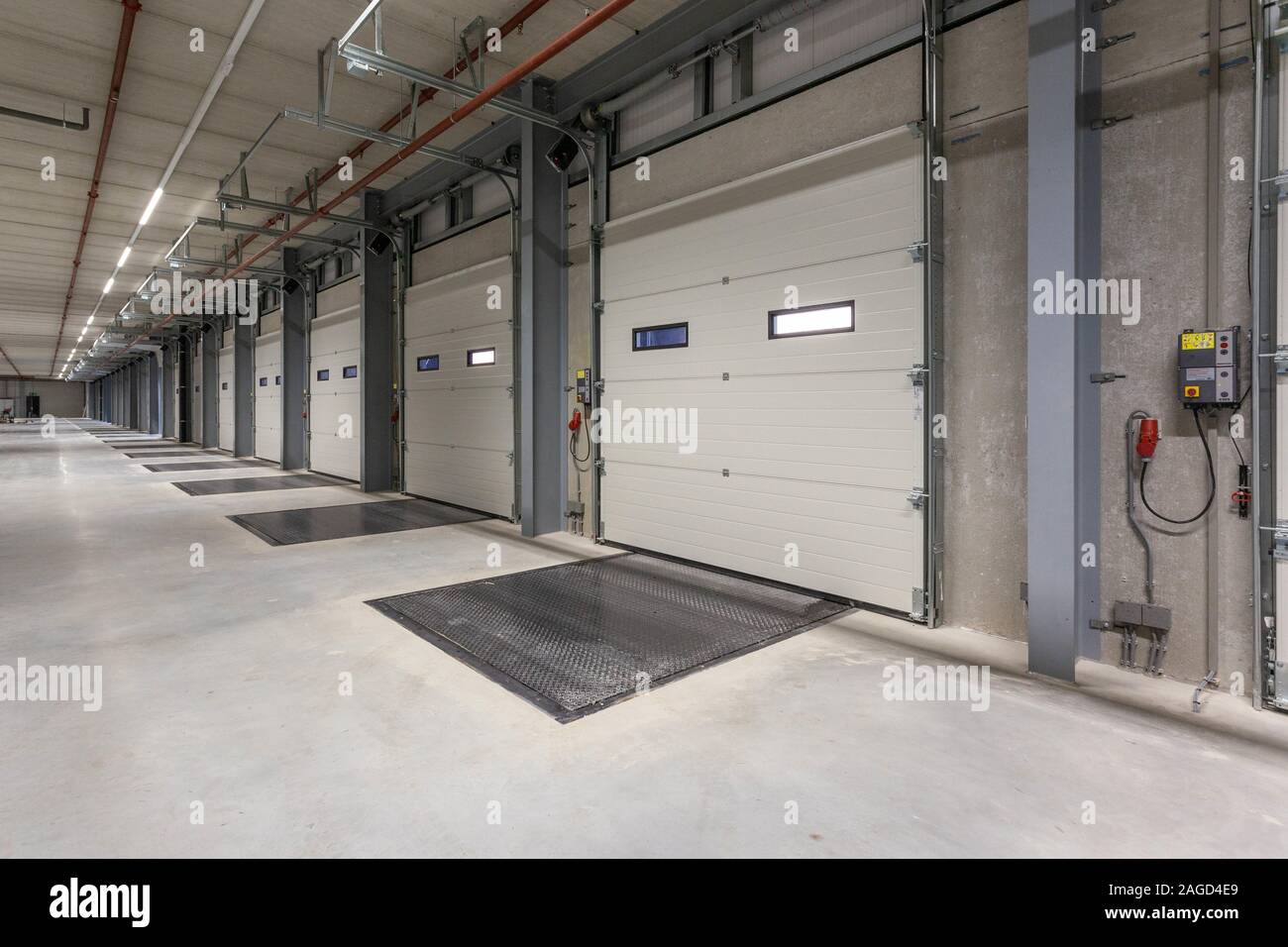 Row of loading docks in a warehouse with turned-on lights on the ...