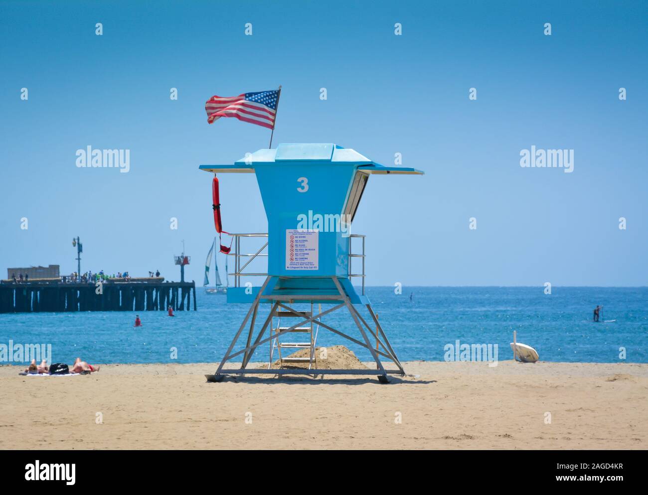 People sunbathing on beach near Sterns Wharf at the Aqua blue lifeguard ...