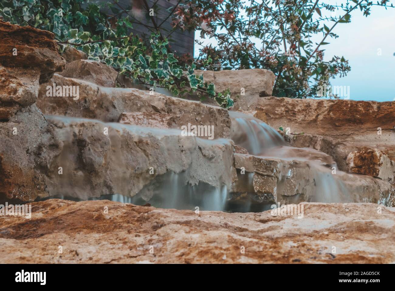 A simple waterfall with some vegetation surrounding it. Low shutter ...