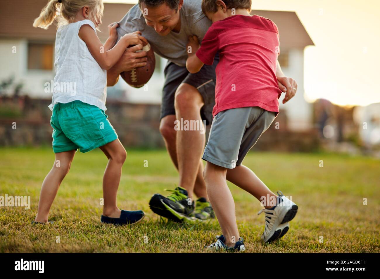 Father playing with his children in their back yard Stock Photo - Alamy